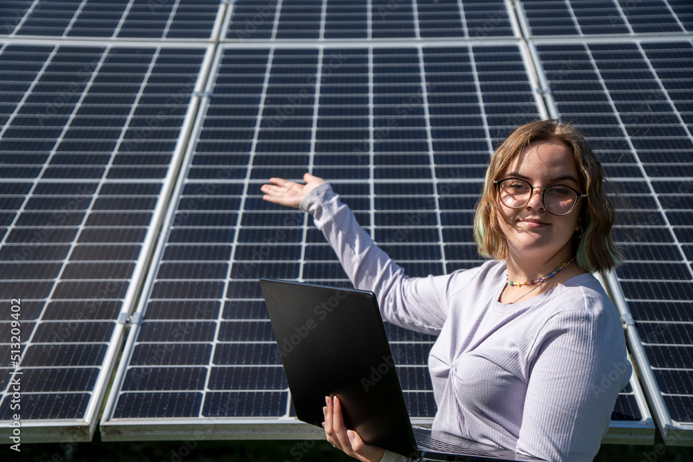 A young female engineer working with solar panels programs and ...