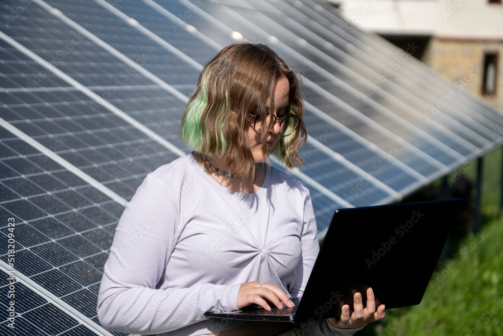 A young female engineer working with solar panels programs and ...