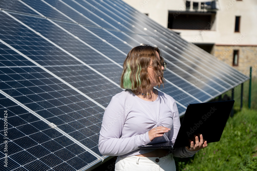 A young female engineer working with solar panels programs and ...