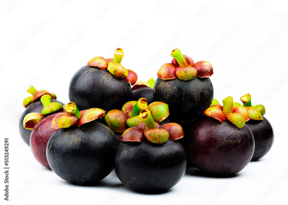 Whole mangosteen showing purple skin isolated on white background with ...