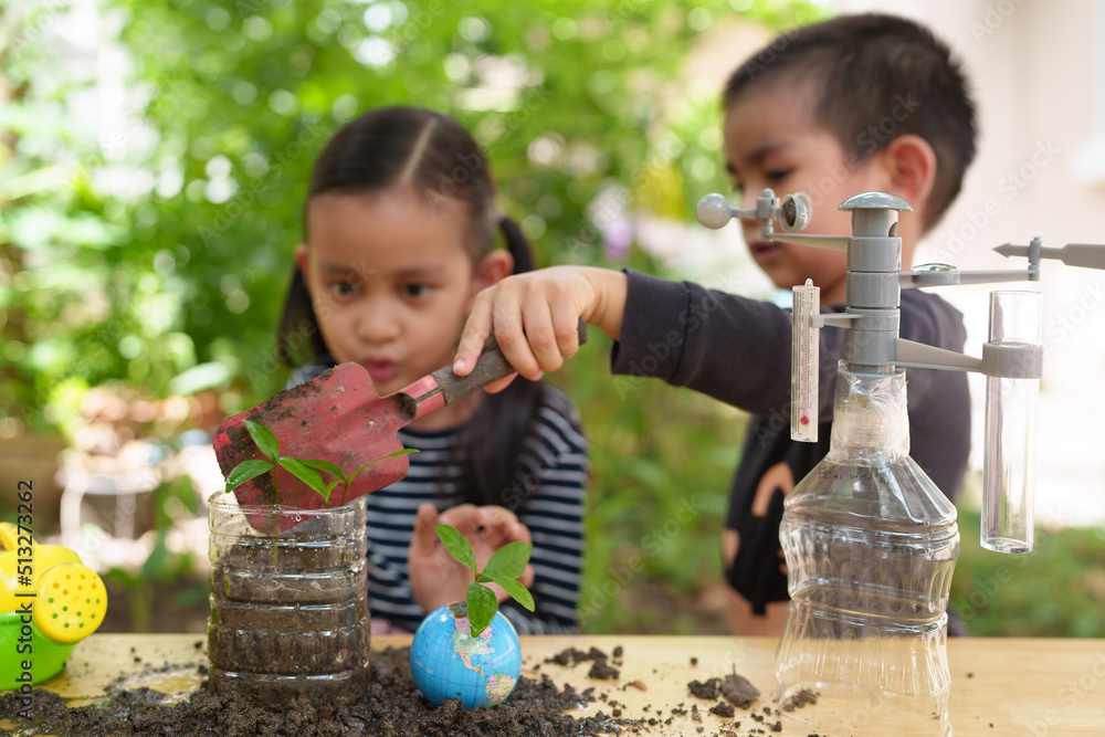 Blurred of asian sibling kid together planting the tree in the recycle ...