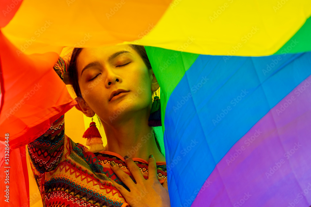 Elegance transgender model woman in colorful rainbow flag costume is ...