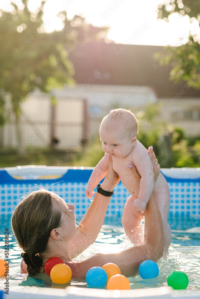 Family playing in the swimming pool. Mother and kids having fun in the pool. Summer leisure and ...