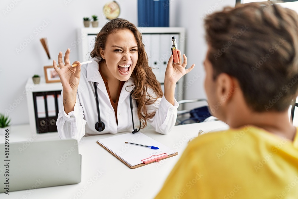 Young doctor woman showing electronic cigarette and normal cigarrete to ...