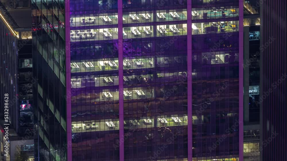 Illuminated panoramic windows in offices of a high class building at ...