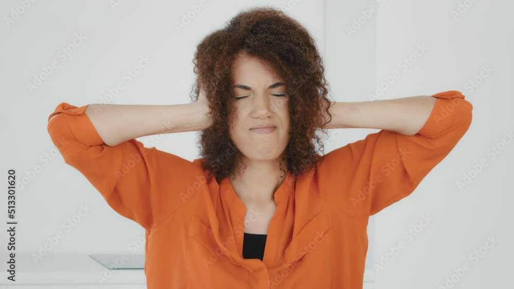 Unhappy stressed African American woman with curly hair covers ears ...