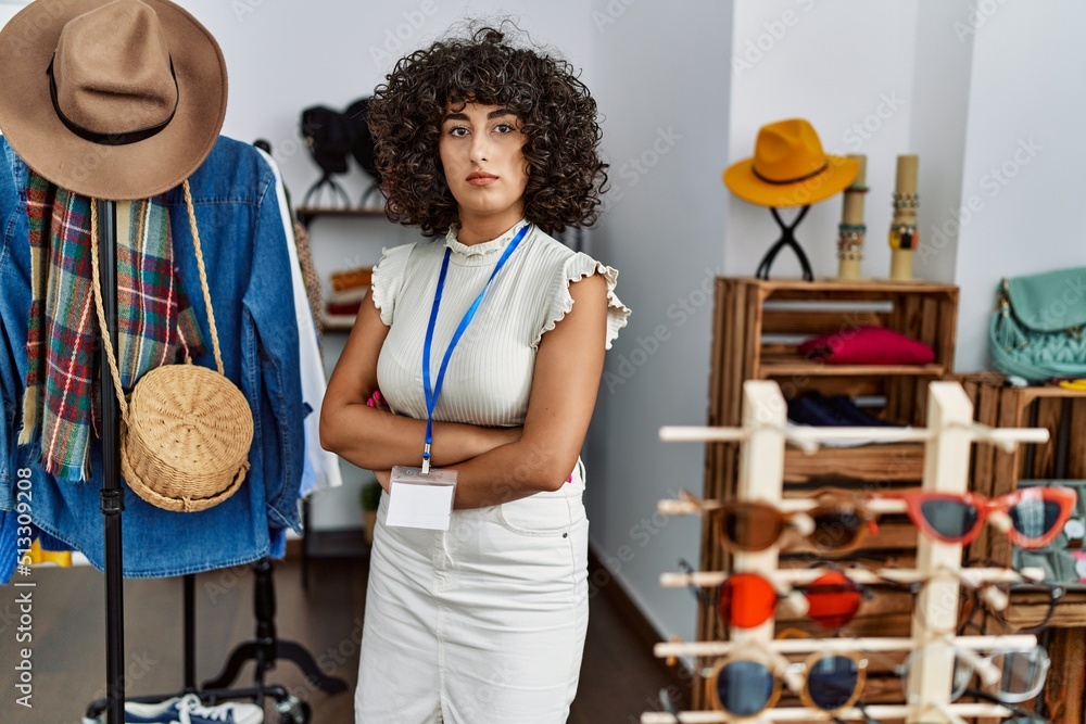 Young middle east shopkeeper woman with serious expression standing ...
