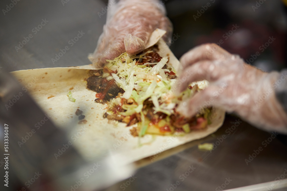the process of cooking shawarma, the hands of the cook. Hands wear ...