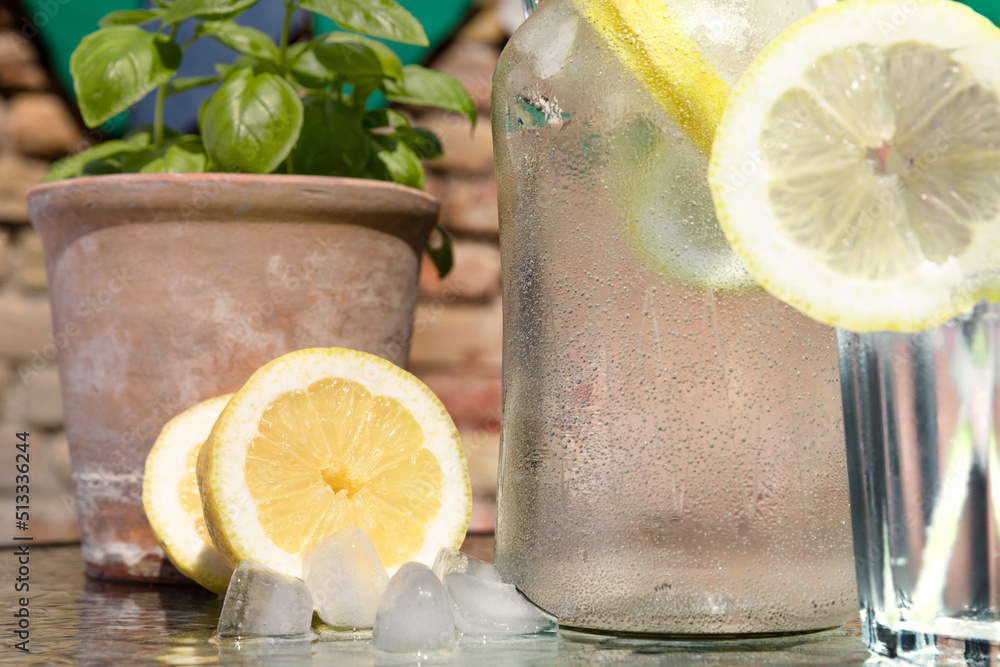 Water fresh and cold in a hot summer day with ice cubes and lemon. Heat ...