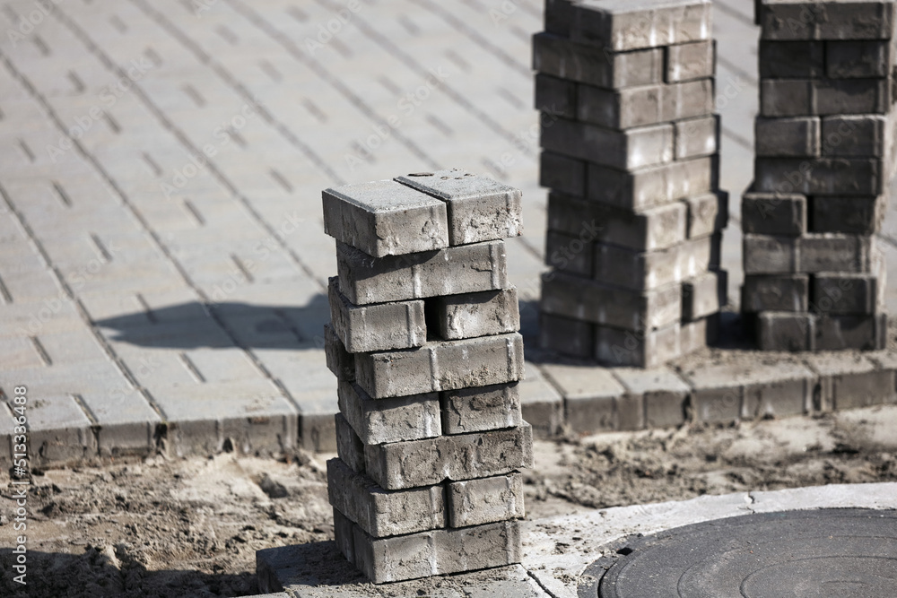 View of new paving slabs and concrete blocks on summer day at ...