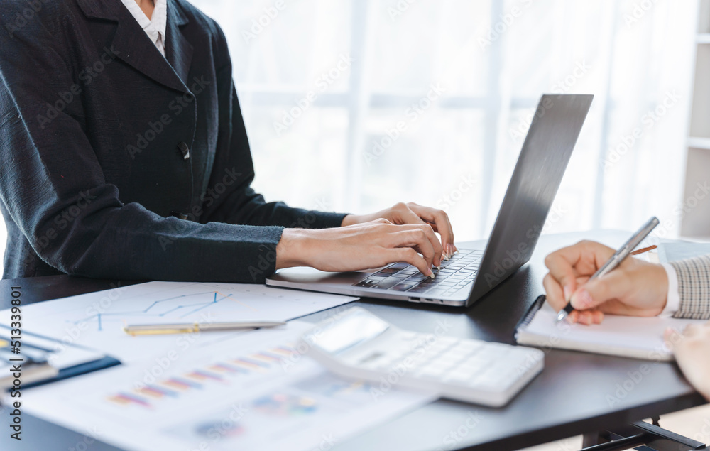 Close up two woman hands working together with laptop and calculator to ...