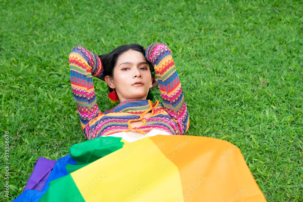 Transgender woman wearing rainbow blouse covering lgbt rainbow flag ...