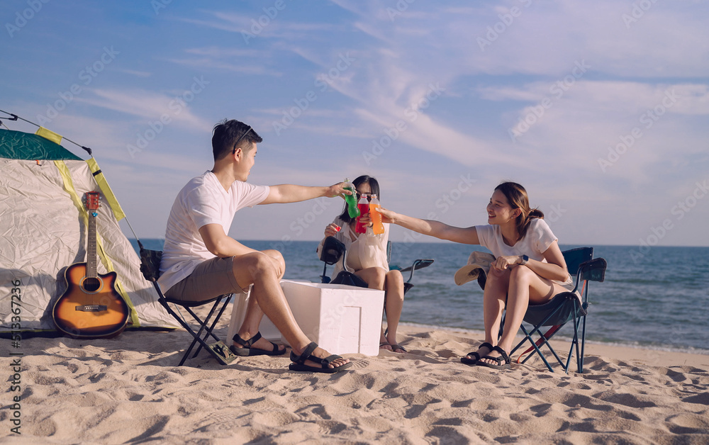 Group of happy Asian young friends sits on picnic chair holding soft ...