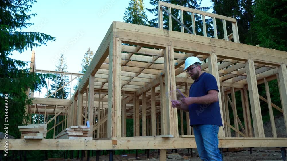 Construction worker builds a house using a hummer. Wooden House Frame ...