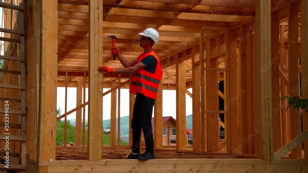 Construction worker builds a house. Caucasian Contractor and the Wooden ...