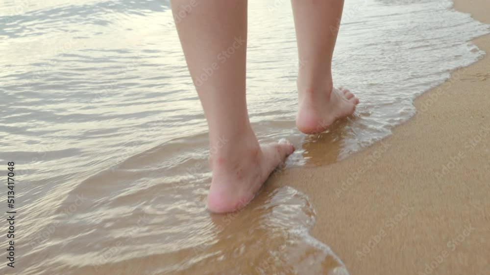 Back view, Close up foot of young beautiful woman walking into tropical ...