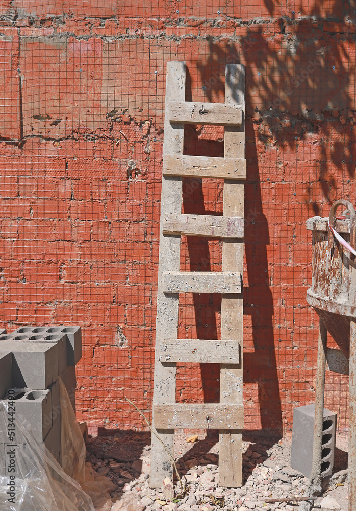 Wooden ladder lean against brick wall. Ladder on a construction site ...