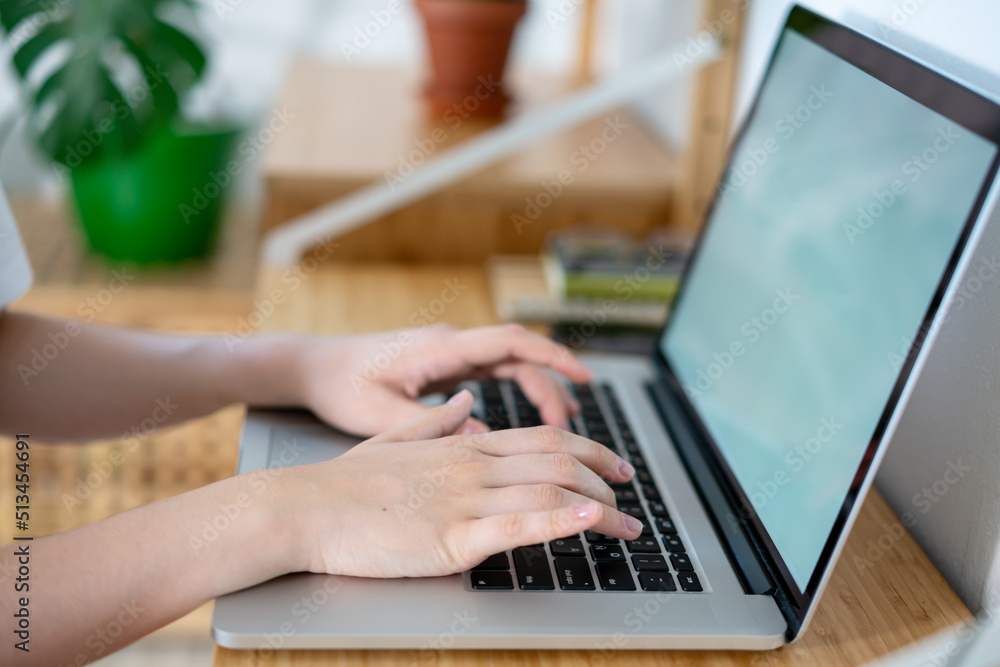Female hands typing text messages on a laptop keyboard close-up. Busy ...