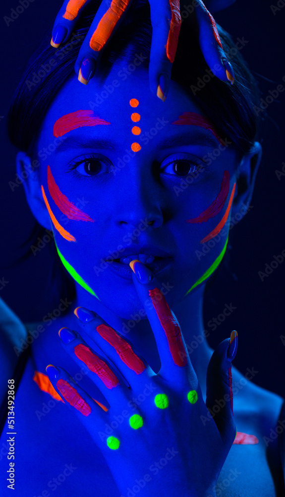 Unusual fluorescent makeup on the skin of a beautiful woman, glowing ...