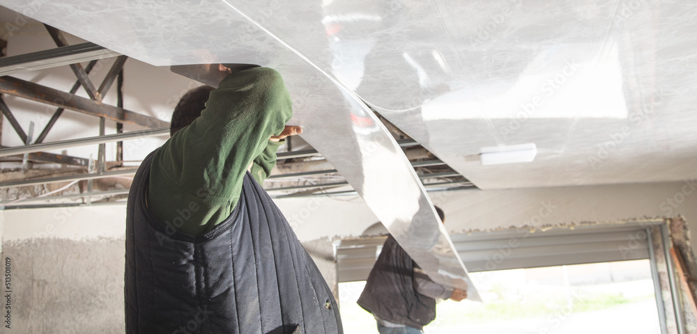 Construction worker assemble a suspended ceiling. Stock Photo | Adobe Stock