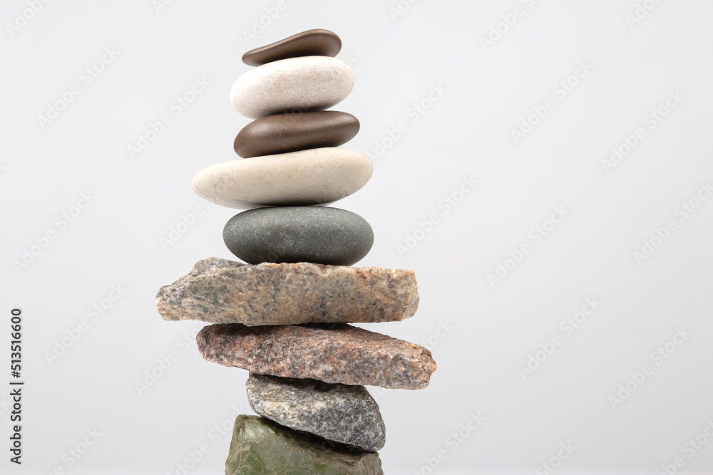 pyramid of stacked stones on a light background. stabilization and ...