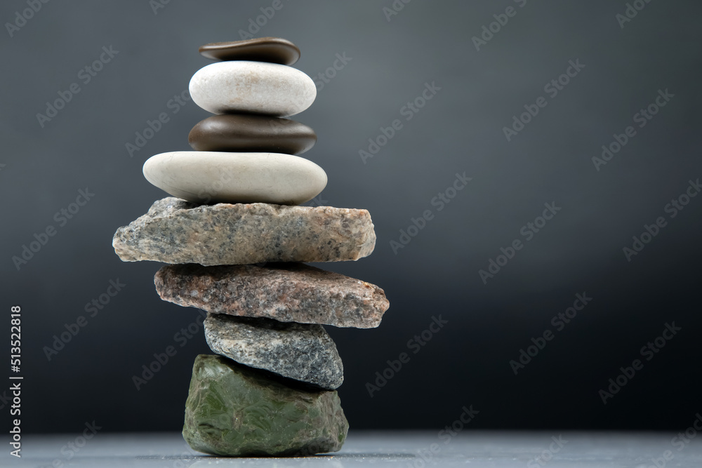pyramid of stacked stones on a dark background. stabilization and ...