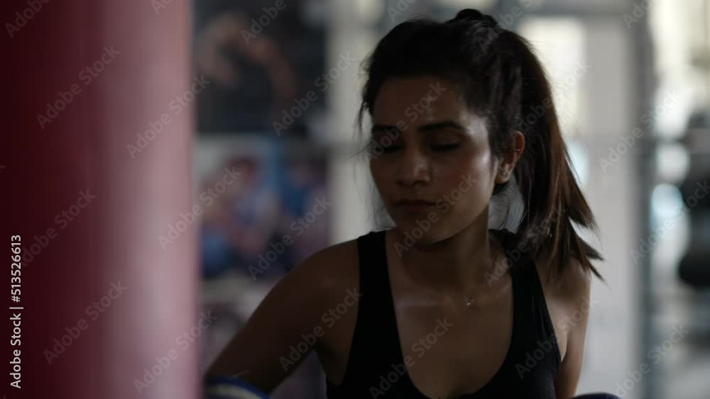 Kickboxing, A young Indian woman fighter trains his punches, beats a ...