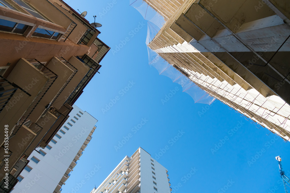 View from below of new multi-storey buildings, a tower crane, multi ...