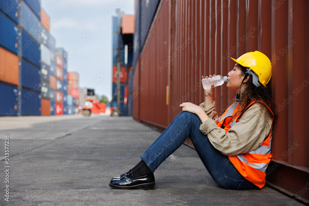 the logistic worker is sitting and drink cold water during a break in a ...
