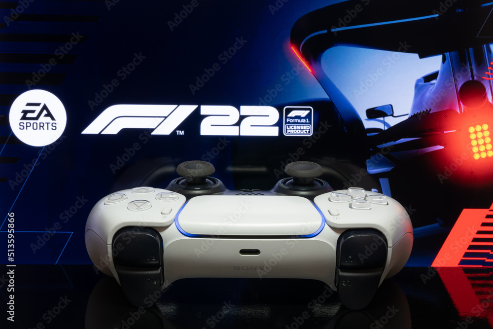 Playstation 5 controller with F1 22 logo at TV screen, selective focus ...