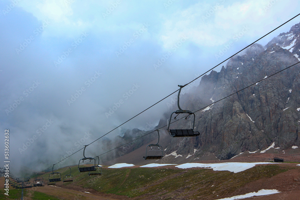 empty open cabins on a cable car in the mountains. fog in the mountains ...