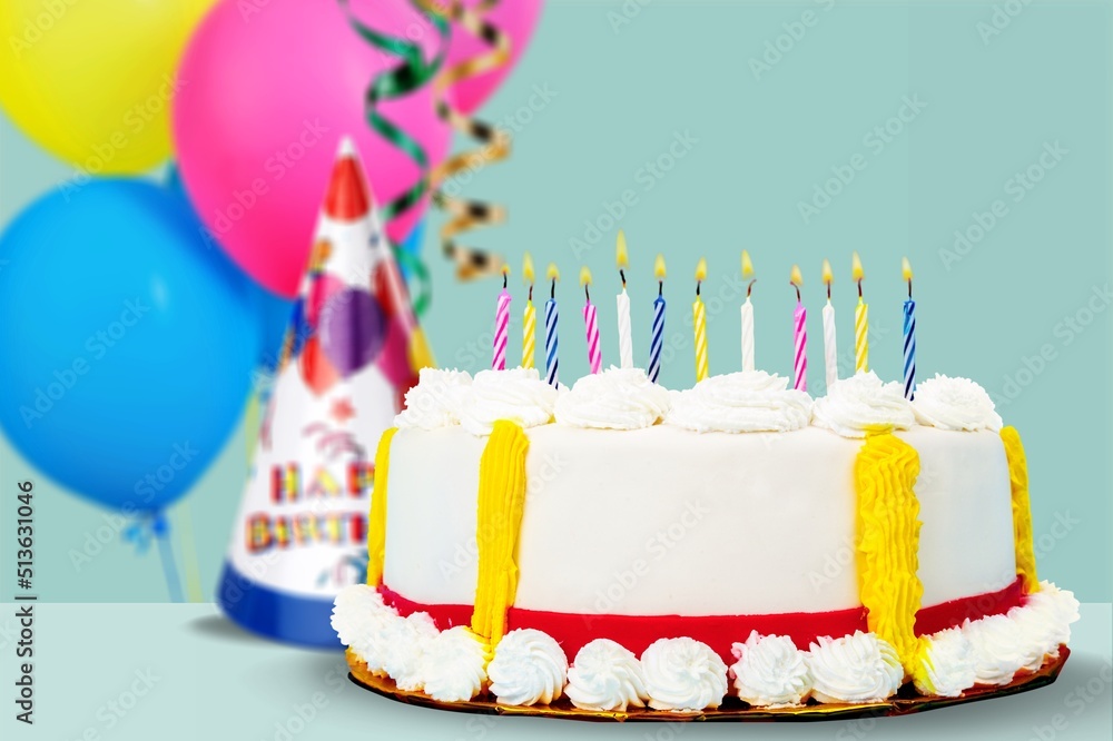 Sweet birthday cake with birthday candle, party hat, streamers and ...