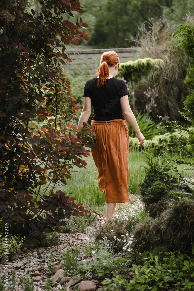 Happy ginger hair woman walking barefoot in the park or garden. Freedom ...