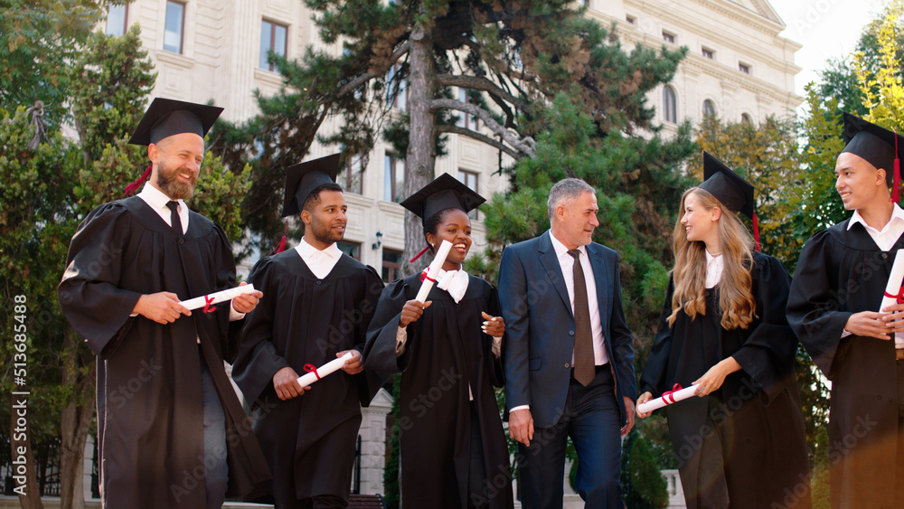Multiethnic graduates students in the college park walking in group ...