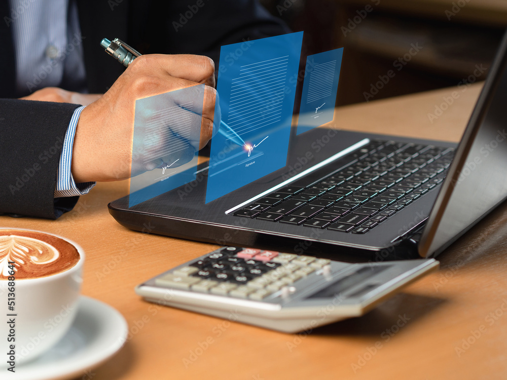 Electronic signature and paperless office concept. A businessman uses a ...