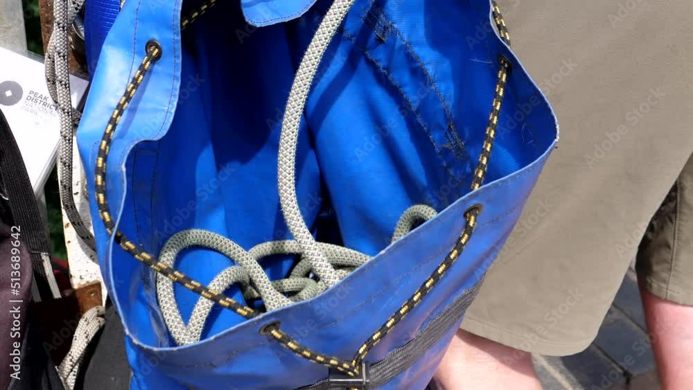 Close up of blue bag by the leg of man who is pulling mountaineering ...