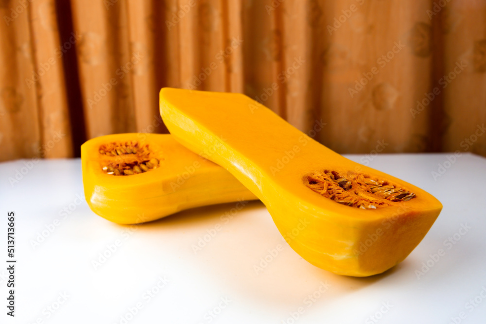 Two halves of an Butternut Squash (Cucurbita moschata) on white table ...