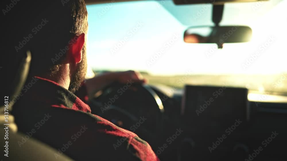 Rear view in saloon auto on male who driving on rural road. Blurred ...