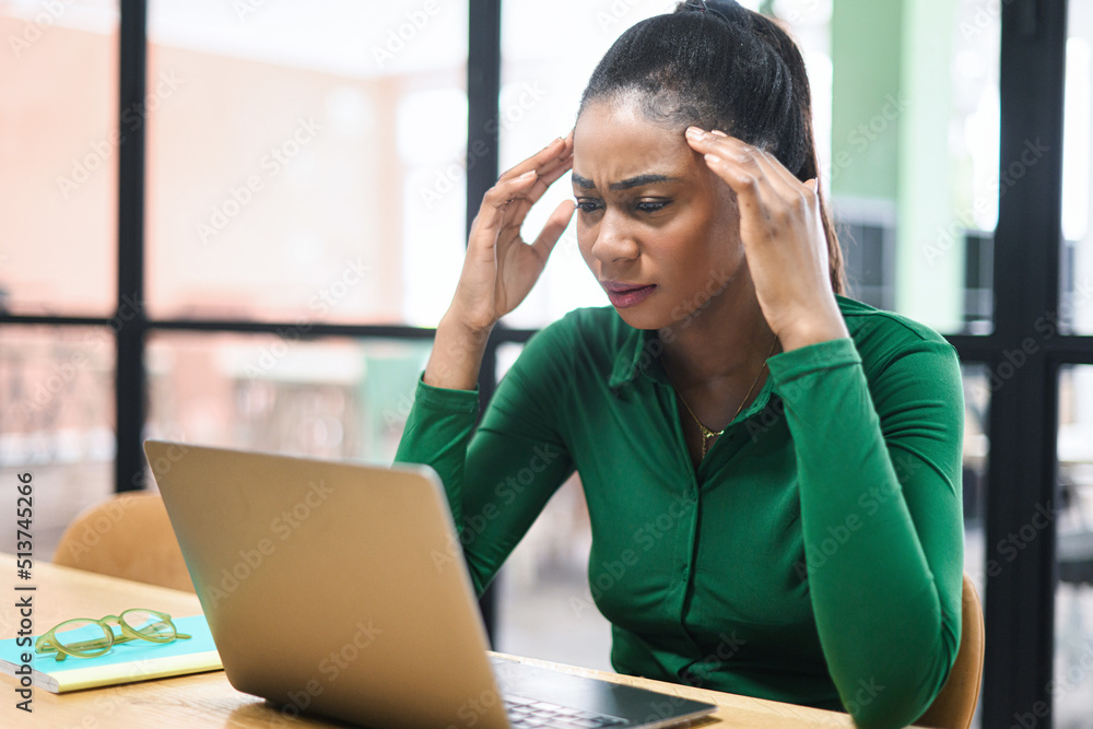 Worried african-american female employee colleague staring at laptop ...