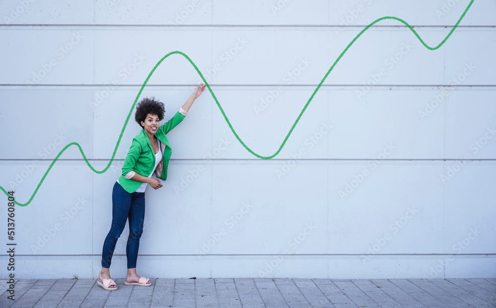 Young woman pointing at chart painted on wall Stock Photo | Adobe Stock