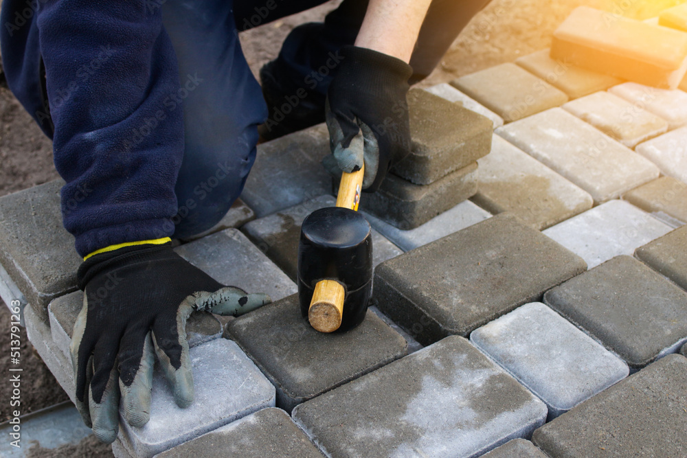 Defocus paver master. Man lays paving stones in layers. Garden brick ...