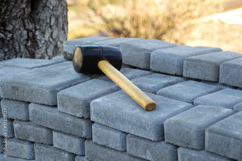 Defocus paving hammer. Stack of paving stones. Garden brick pathway ...