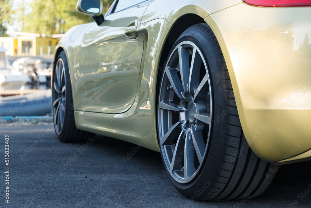 The golden car. Advertising concept. Car wheels close-up on asphalt ...