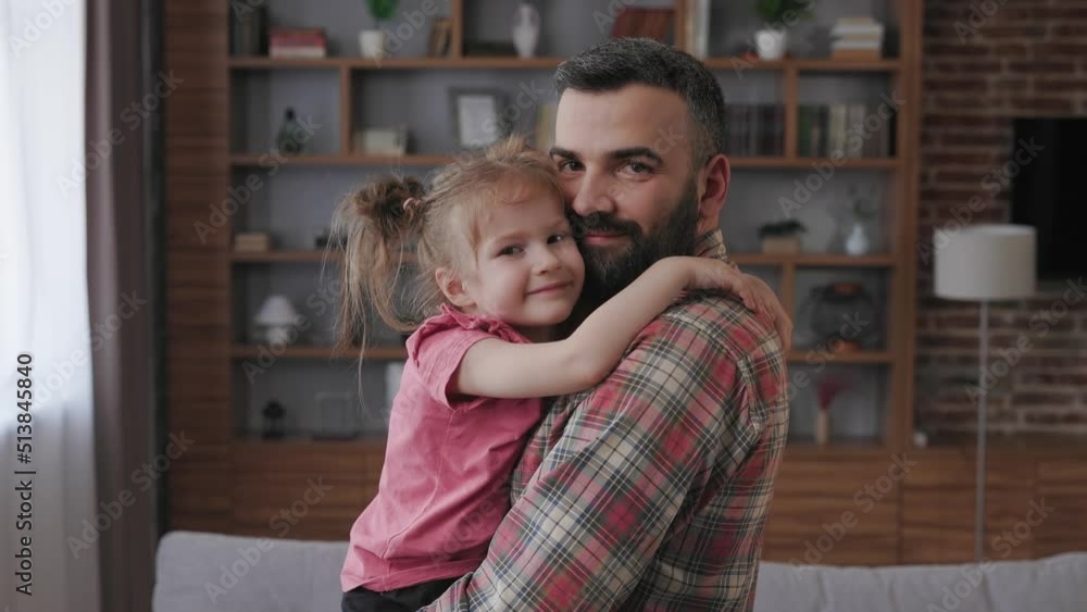 Happy cheerful family. Cute girl hugging her beloved dad around neck ...