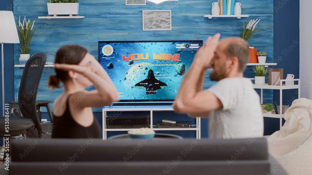 Gamer couple doing high five hand gesture celebrating victory in online ...