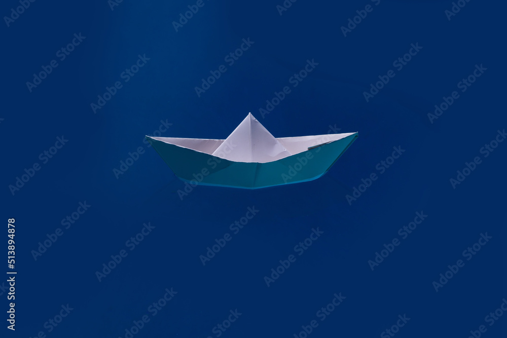Paper boat sailing on blue water surface. Paper ship. Paper boat in ...