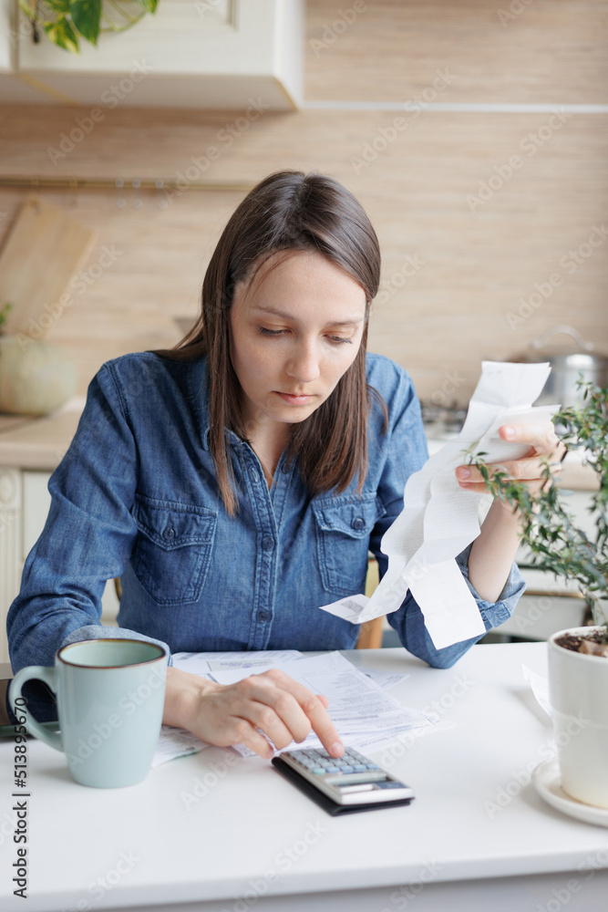 woman pays utility bills and writes checks. a European woman at home ...