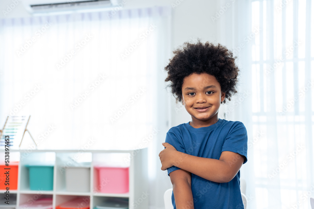 Portrait of African black child boy standing crossed arm in classroom ...