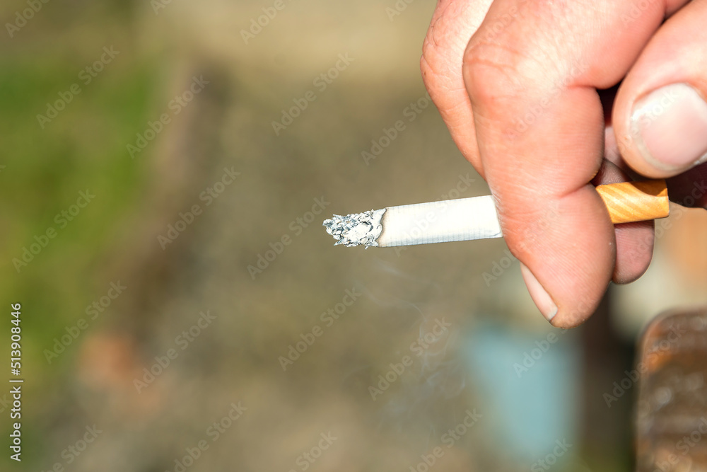 Cigarette in hand. Harm to human health. Hold a cigarette with your ...