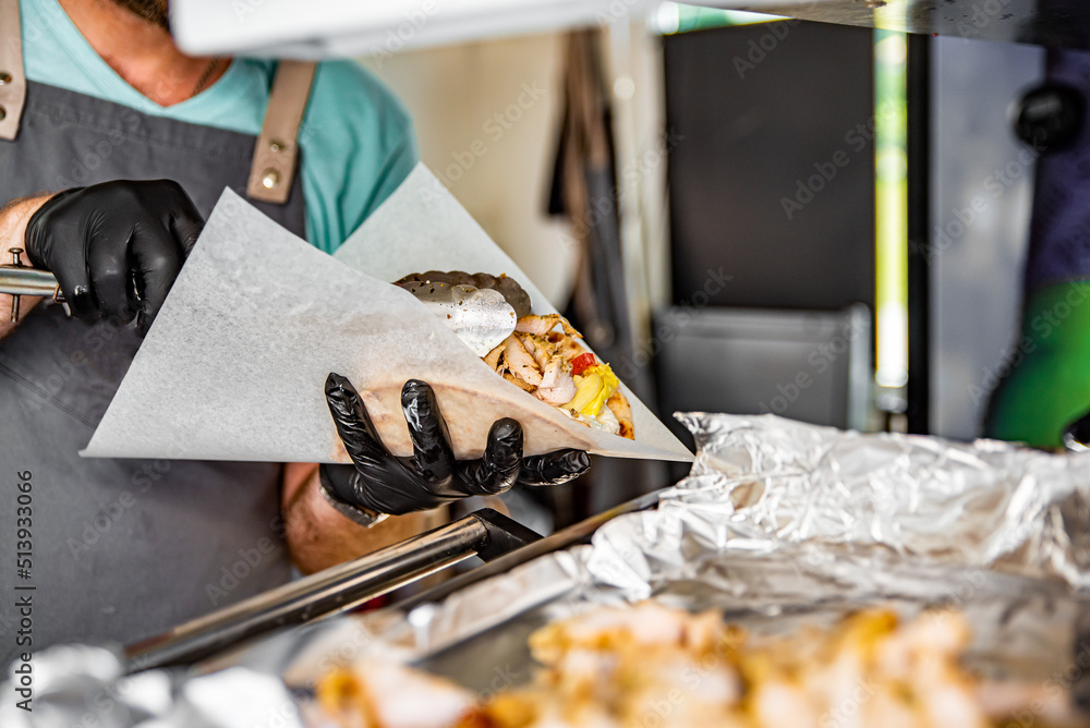 preparing traditional greek fast food - gyros. chef hand cooking food ...